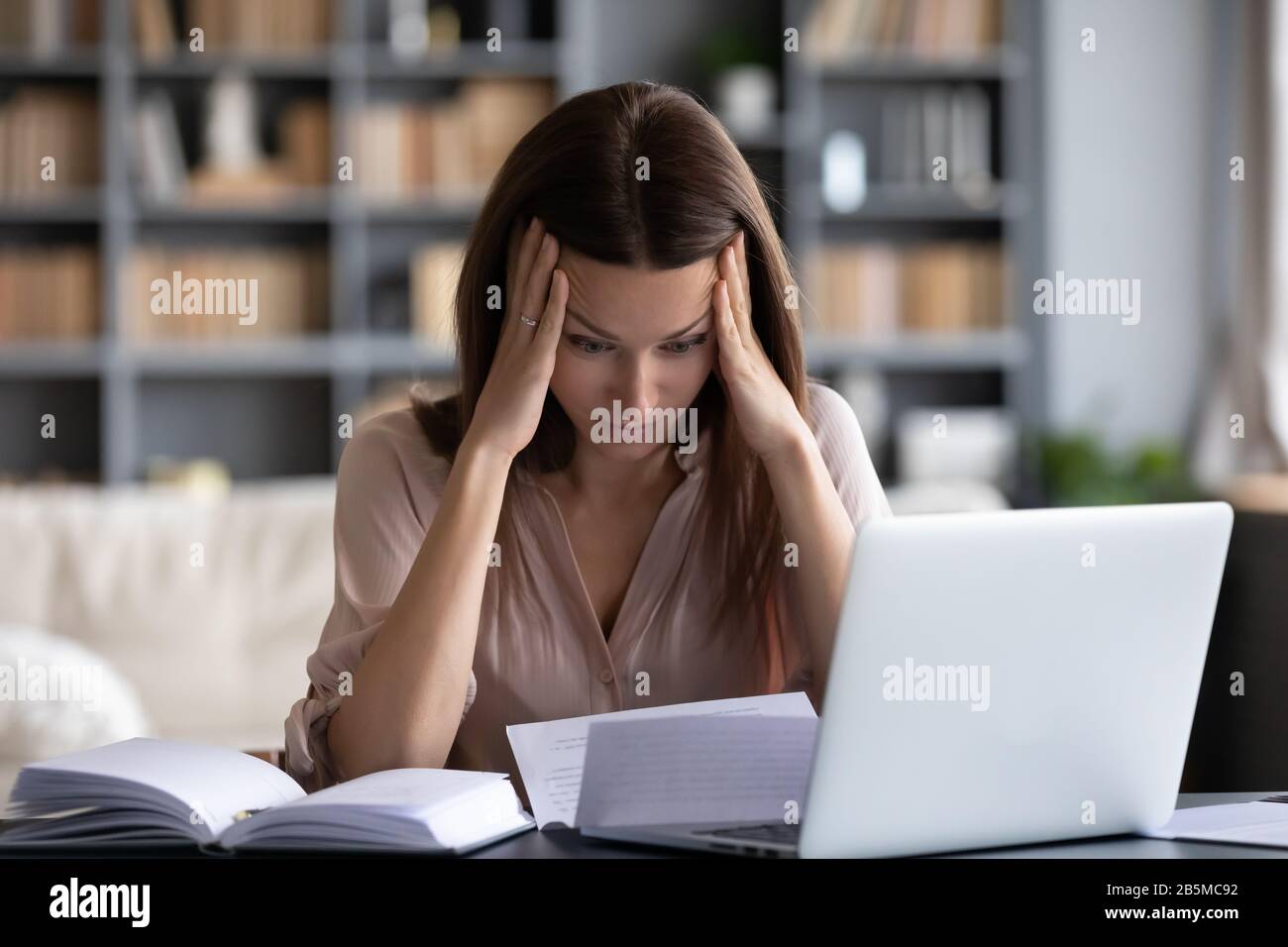 Stressed young woman holding head in hands, feeling desperate Stock ...