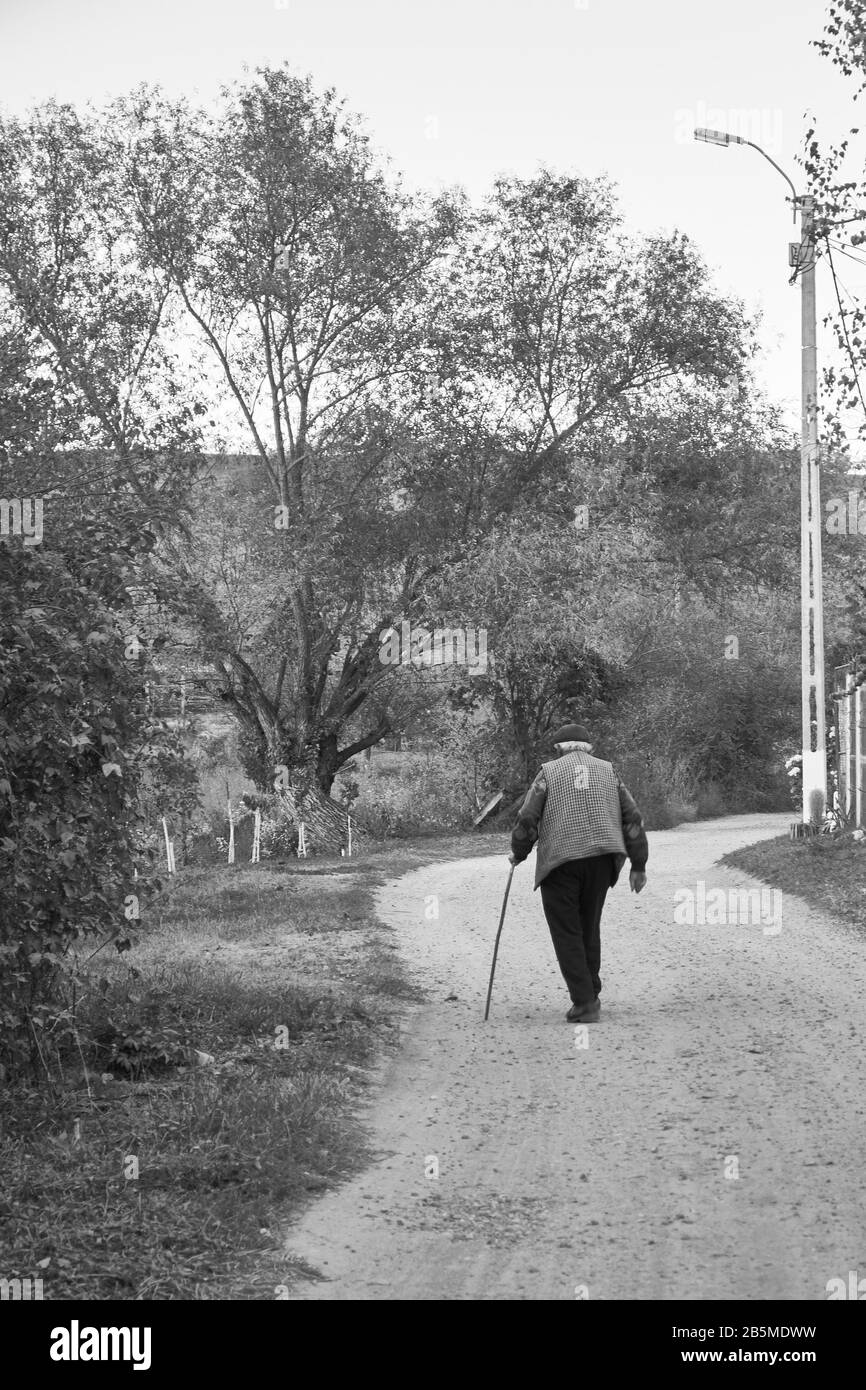 old man walking down the street in village Stock Photo - Alamy