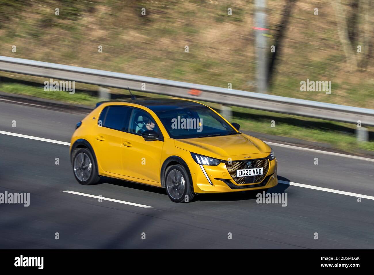 2020 yellow Peugeot 208 GT EV driving on the M6 motorway near Preston ...