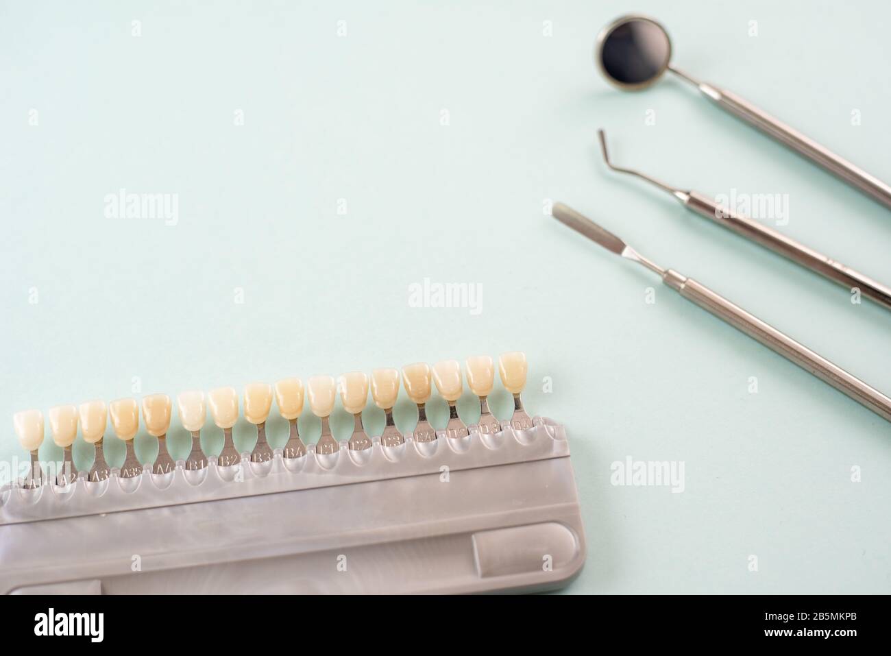 Color palette of different shades of teeth and dental tools on a blue ...