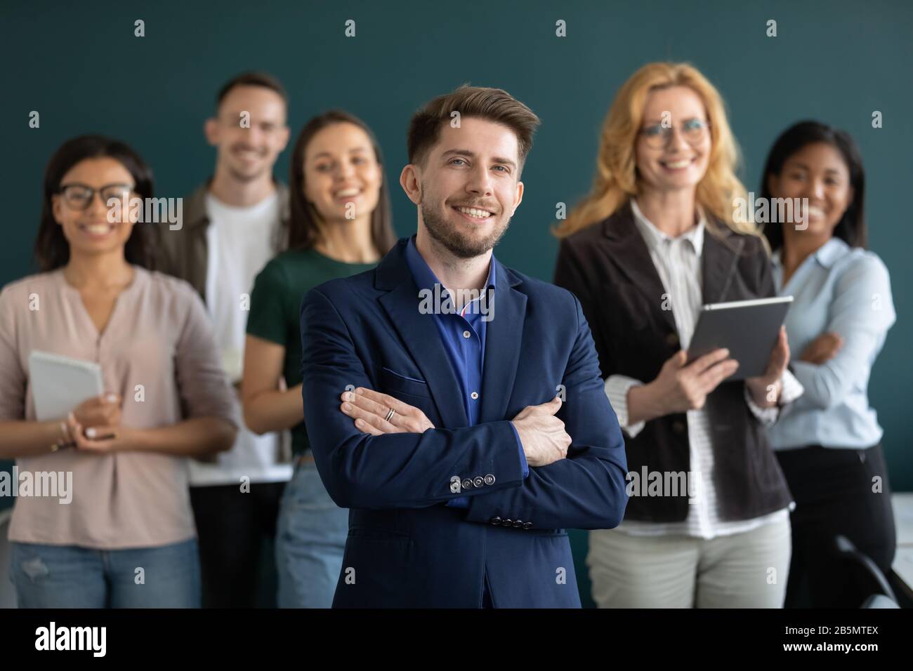 Group picture of diverse employees posing with male boss Stock Photo ...