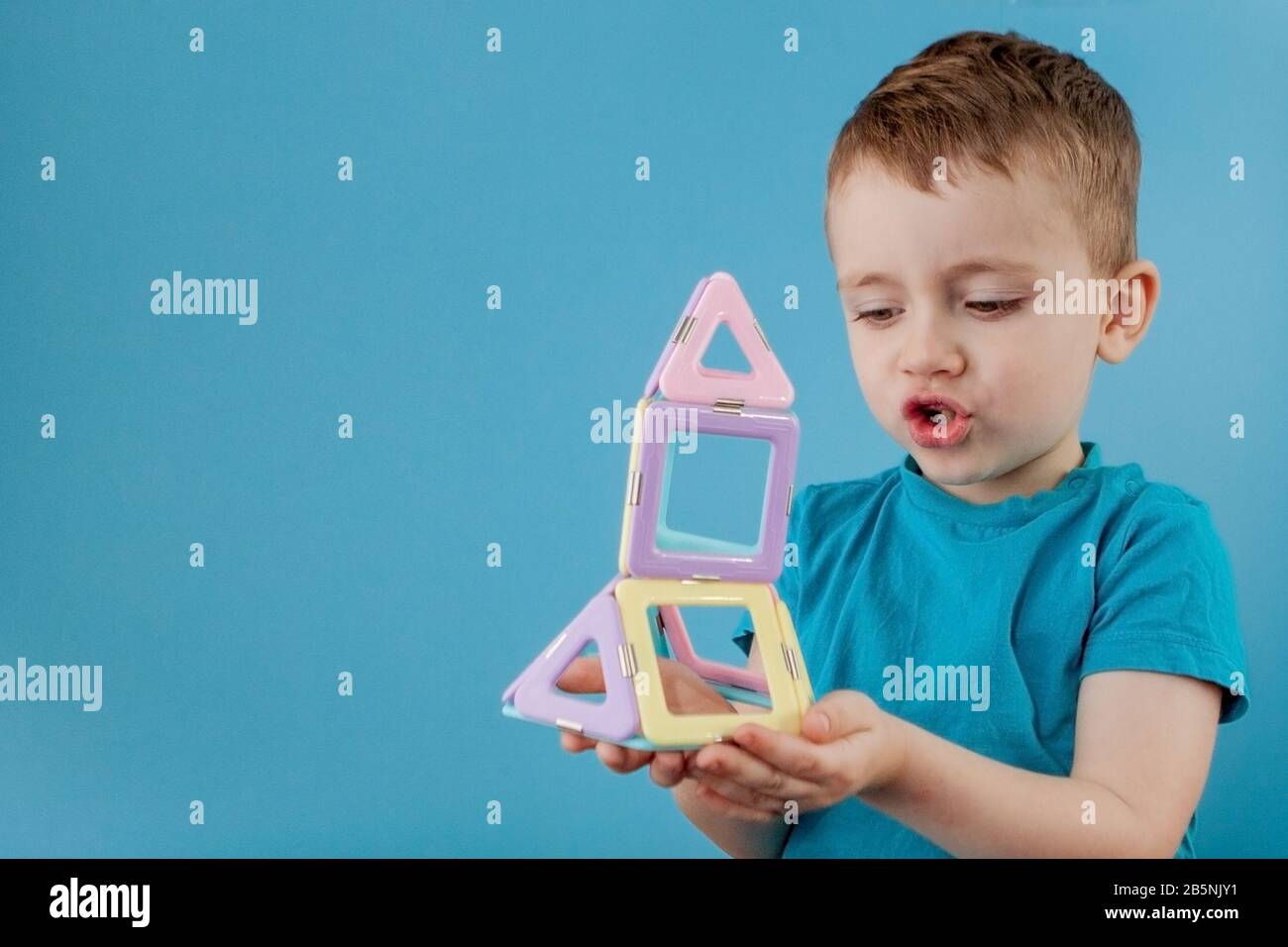 Boy looks through the shape in the color constructor with the ...