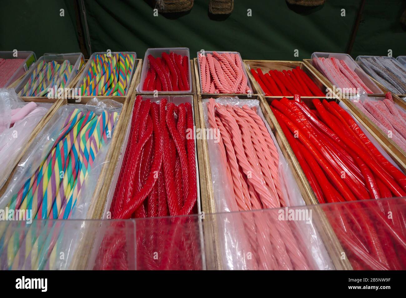 Close-up of boxes of colorful and long candies for sale at a market ...