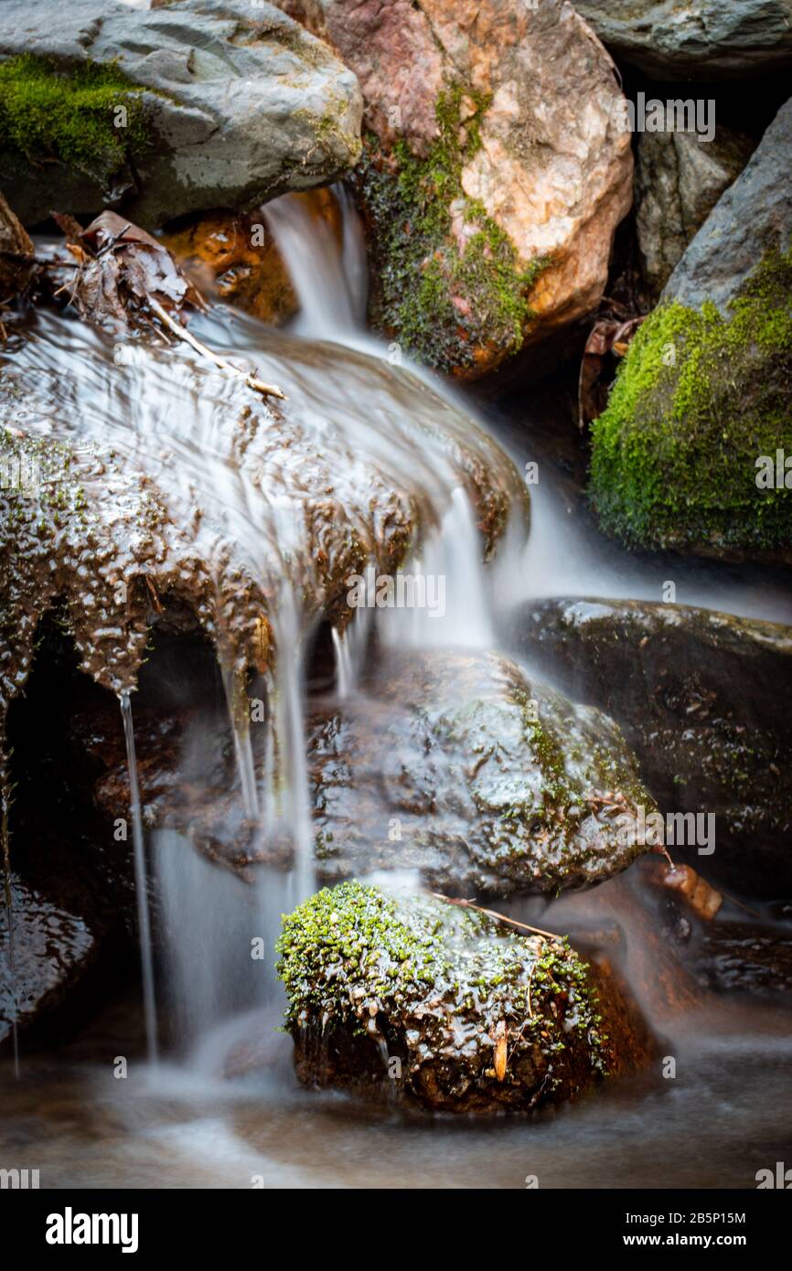 Water flowing over stone in river Stock Photo - Alamy
