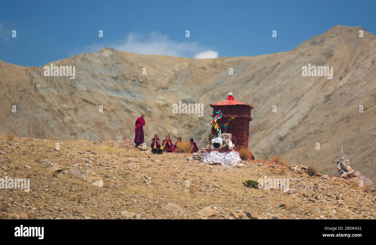Novices rehearse playing the Tibetan horn or dungchen on a hill where ...