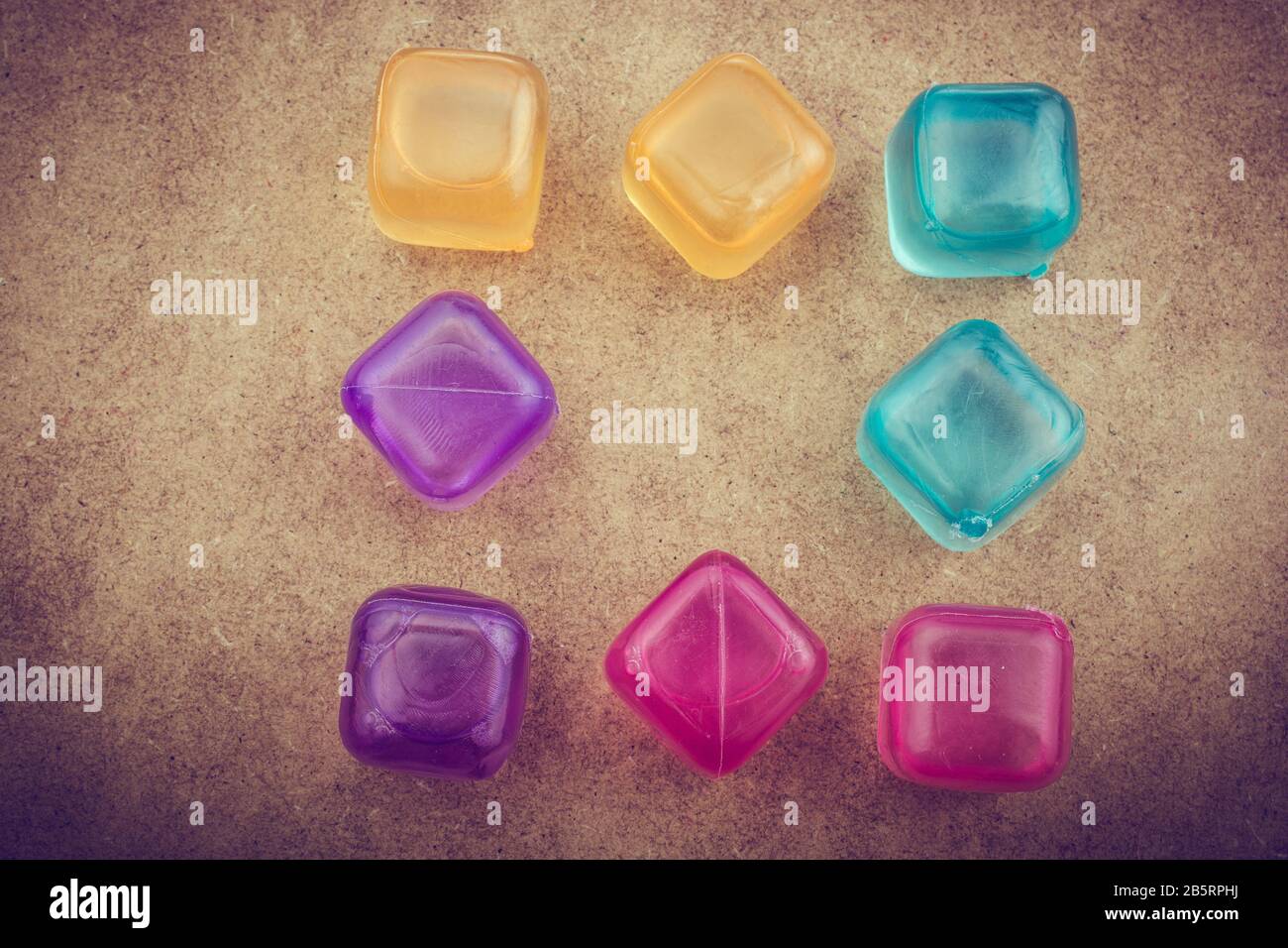Fake colorful ice cubes on a brown background Stock Photo - Alamy
