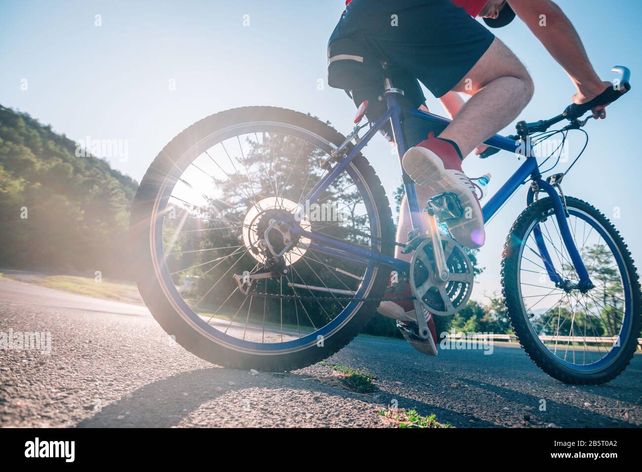 Fit male biker cyclist riding his bike cycle on an asphalt road at ...