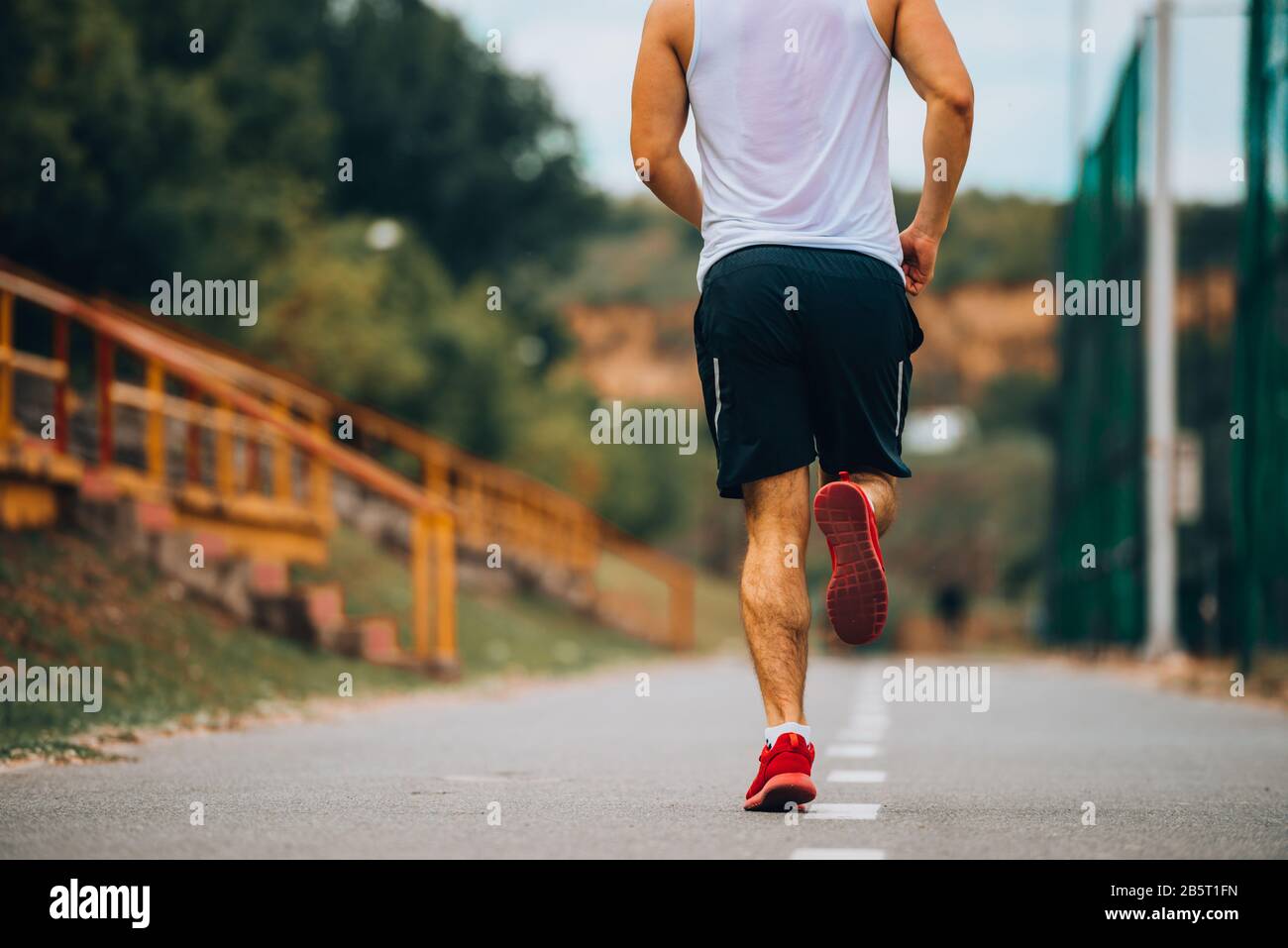 Photo of athlete man running through stadium during spring jog Stock ...