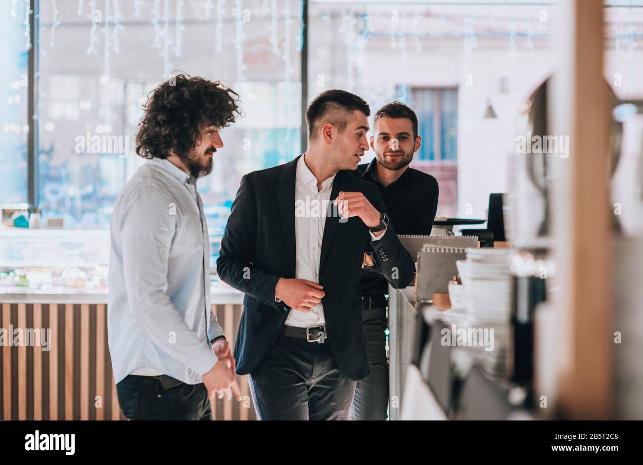 Group of coworkers hanging out in a coffee shop during a business ...