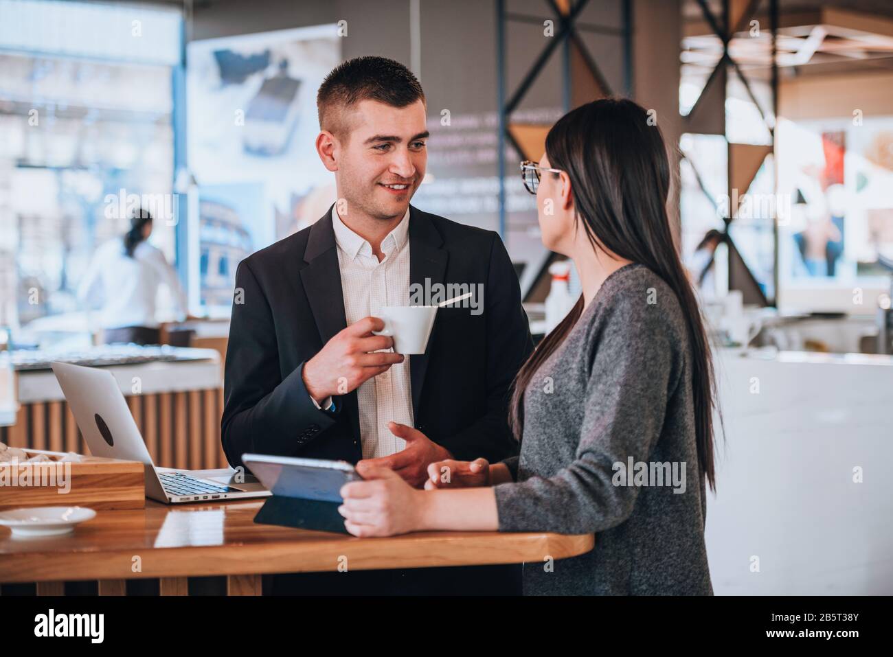 Stylish young people talking with each other at a local coffee bar ...