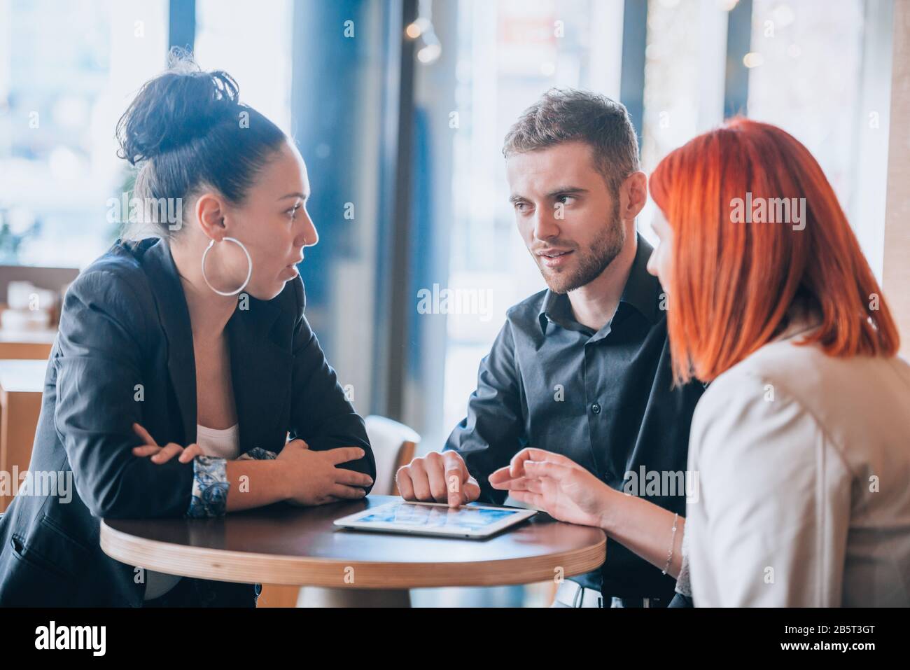 Group of coworkers hanging out in a coffee shop during a business ...