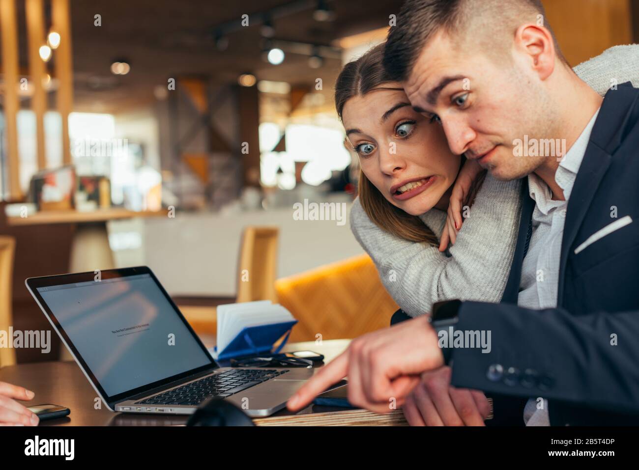 Couple having fun in a cafe ( coffee shop) while making crazy faces and ...