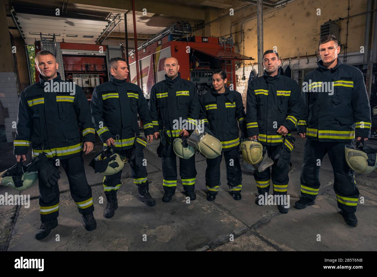 Portrait of firefighters standing by a fire engine Stock Photo - Alamy