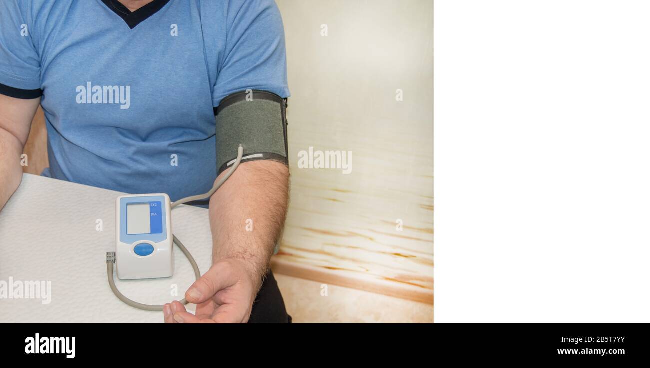 An elderly man independently measures his blood pressure and heart rate ...