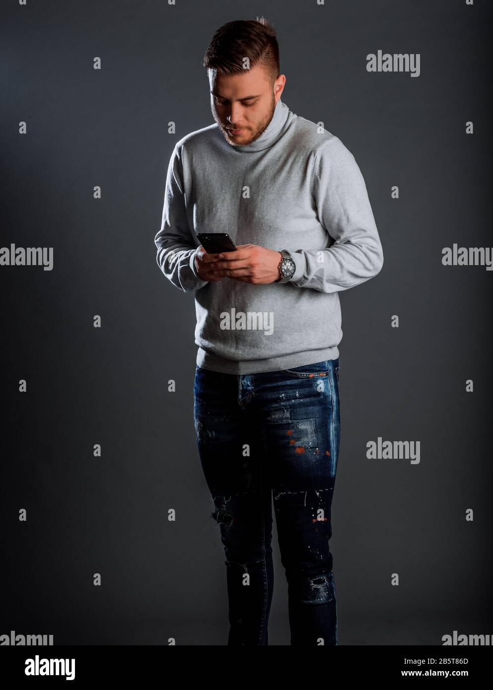 Body shot of an attractive male model posing in modern stylish sweater ...