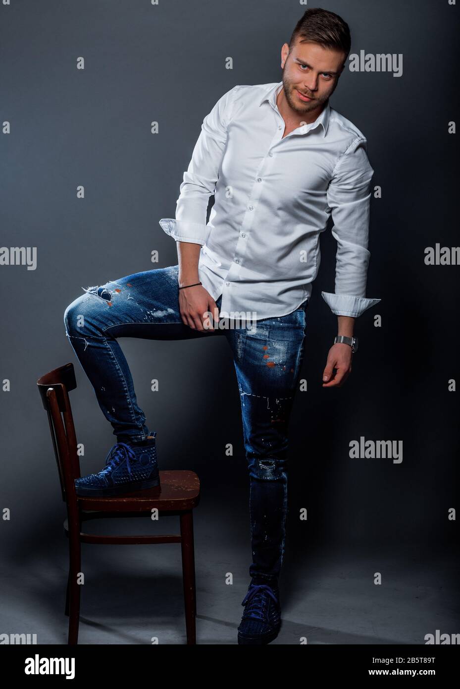 Cool handsome trendy guy wearing stylish white top and ripped jeans ...