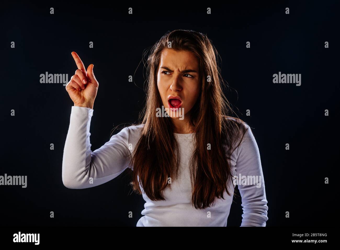Beautiful angry brown-haired angry girl accusing everyone isolated over ...