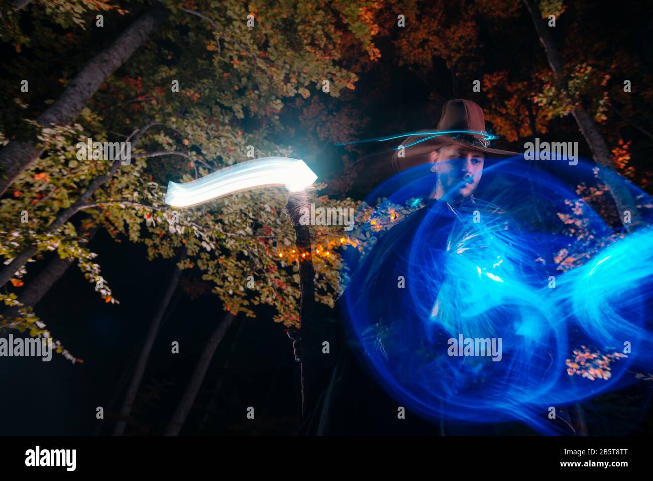 Wizard (mage) casting a spell with his magical staff while standing in ...