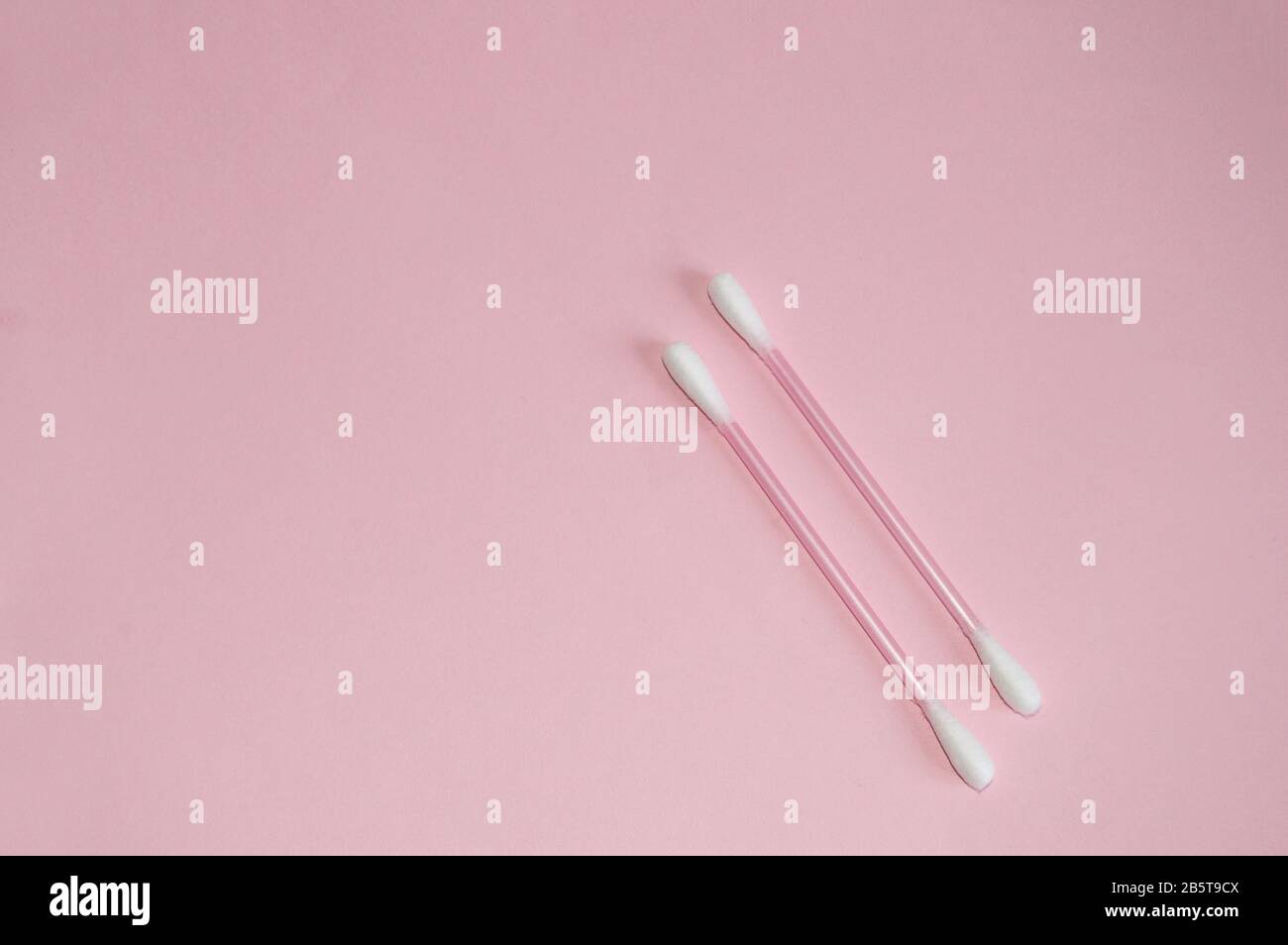 Top view, flat lay, two pink plastic cotton swabs neatly arranged on a ...