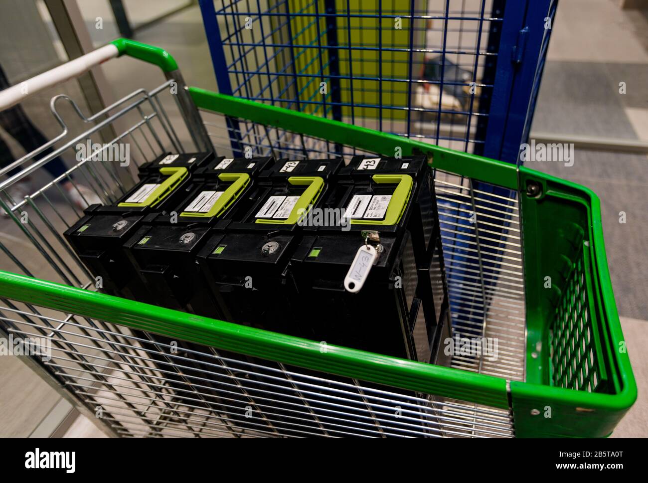 Four safety boxes full of counted cash placed in a cart for ...