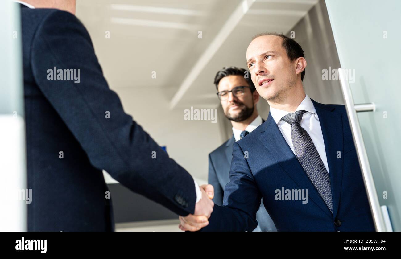Group of confident business people greeting with a handshake at ...