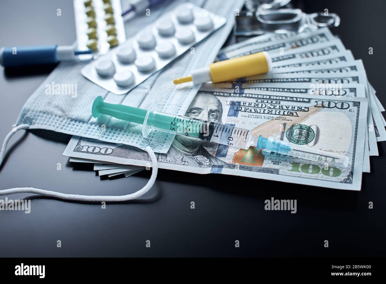 Tablets, protective mask, medical items and dollar bills on dark ...