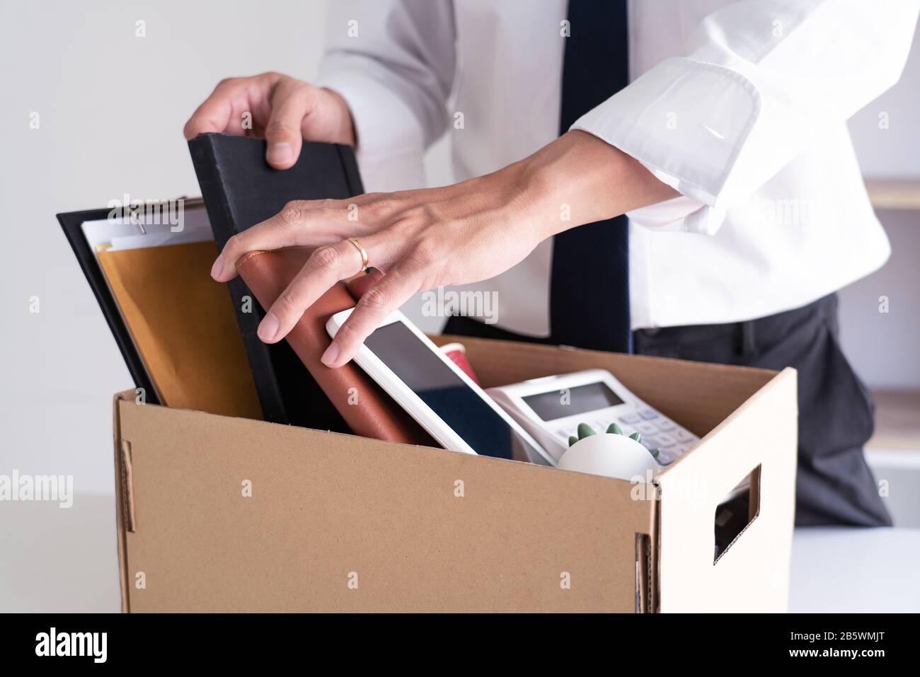 Sad Fired Young Employee businessmen hold boxes including pot plant and ...