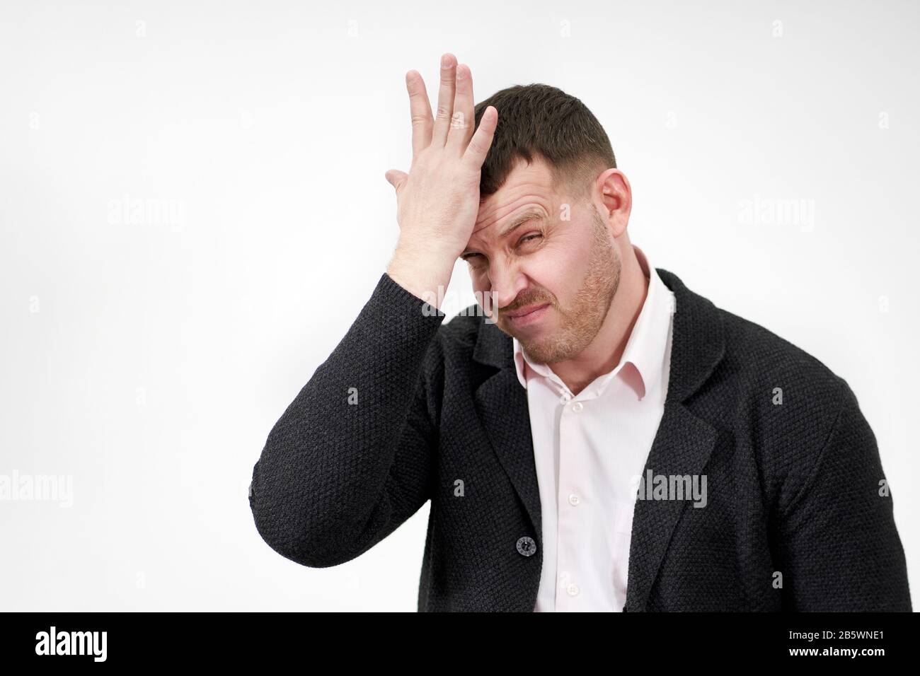Stressed businessman with hand on the forehead over grey background ...