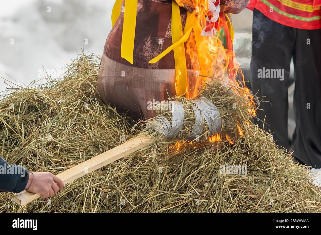 a man sets fire to a straw effigy at a festival Stock Photo - Alamy