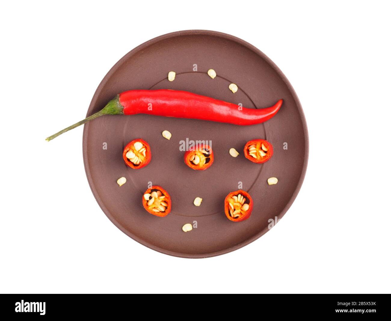 Red chili on brown clay plate isolated on white. Indian cuisine ...
