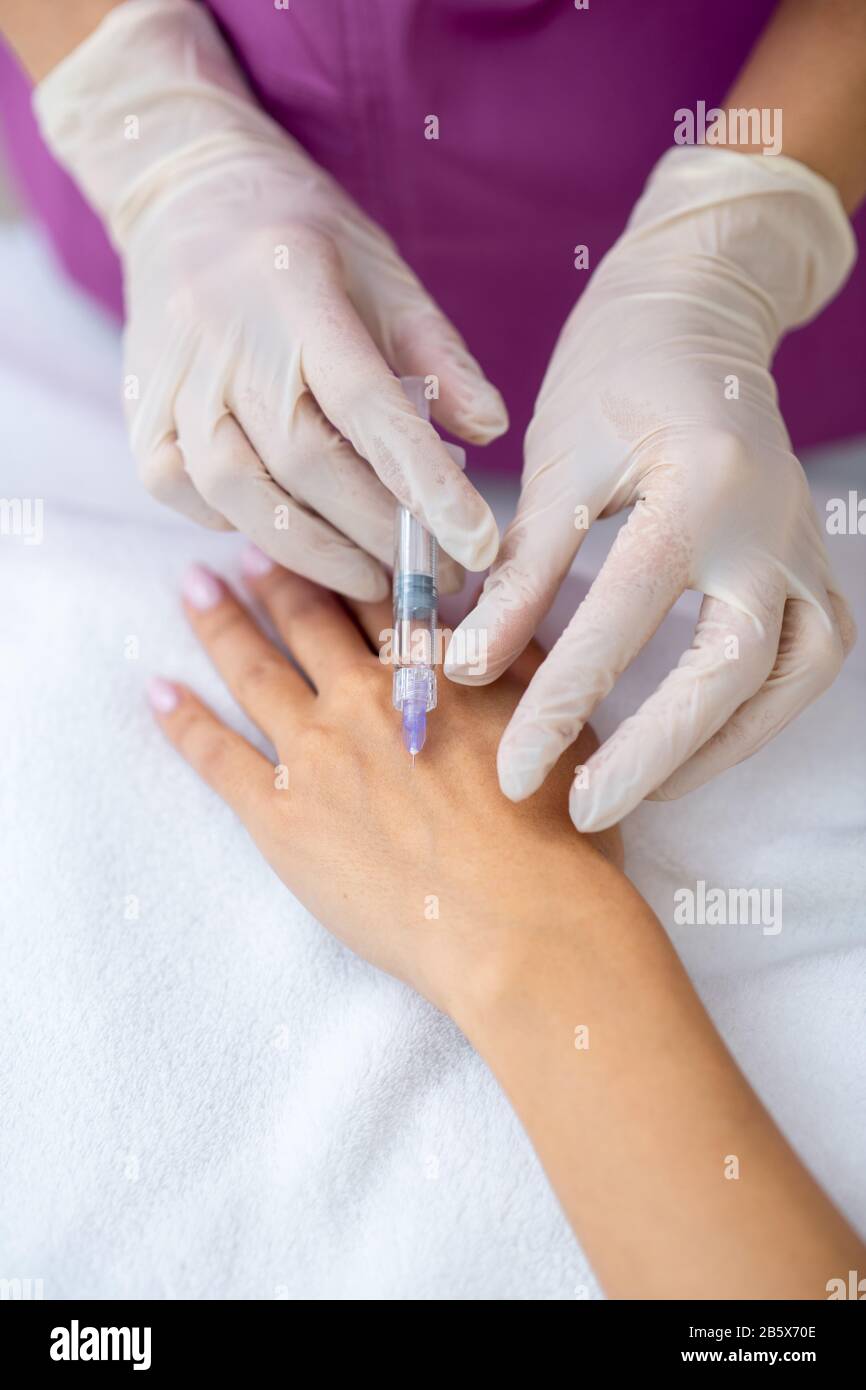Beauty doctor making anti-aging injection into arm Stock Photo - Alamy