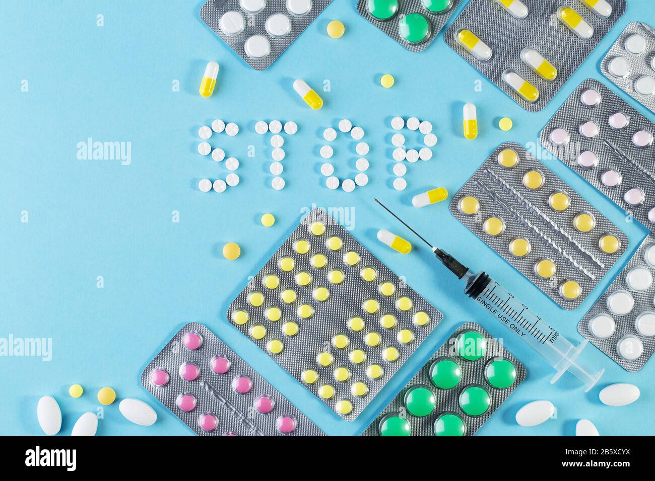 Text phrase STOP on a blue background with pills. Different medicines ...