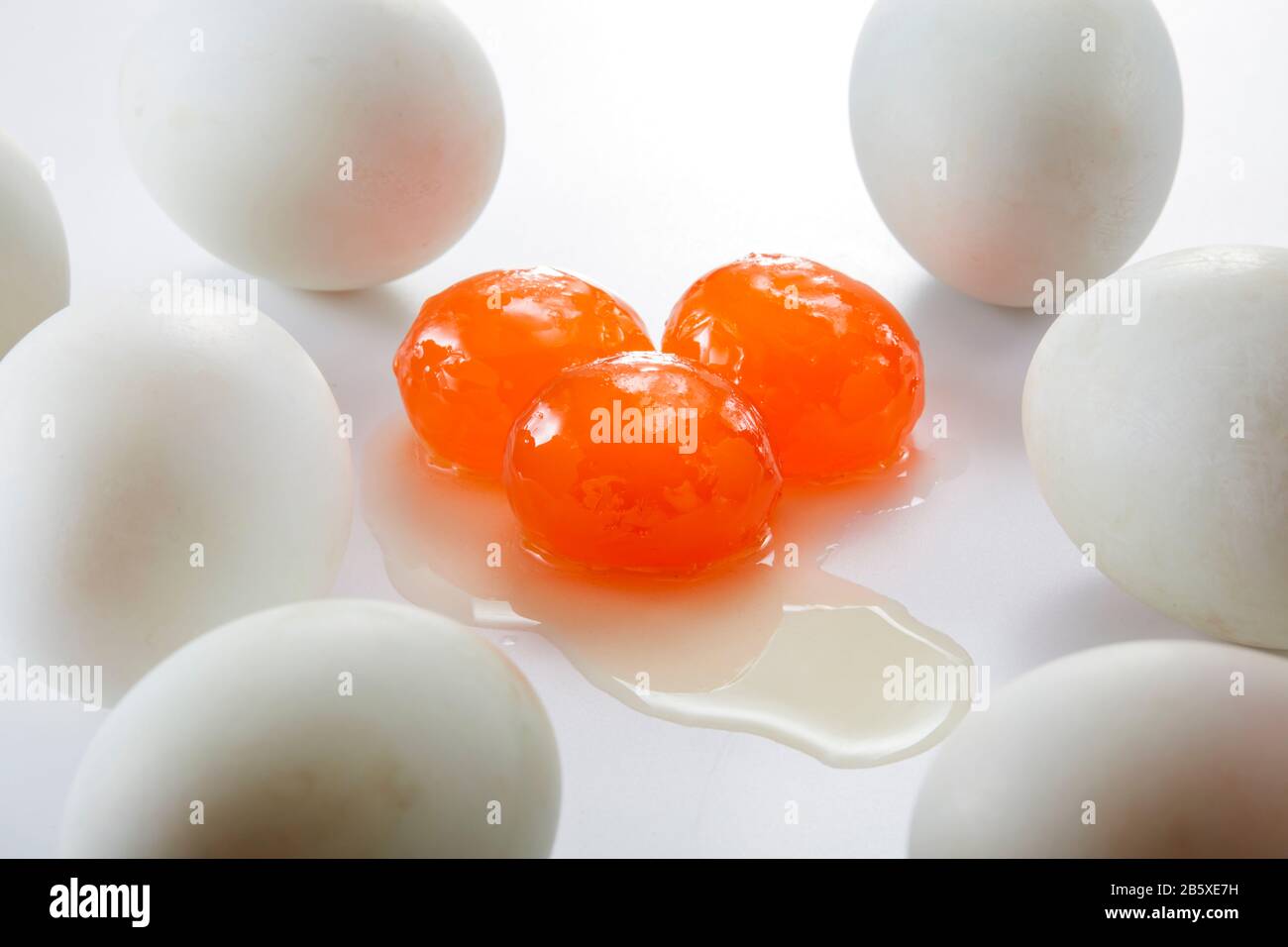 Three salted duck yolks and a pile of salted duck eggs Stock Photo - Alamy