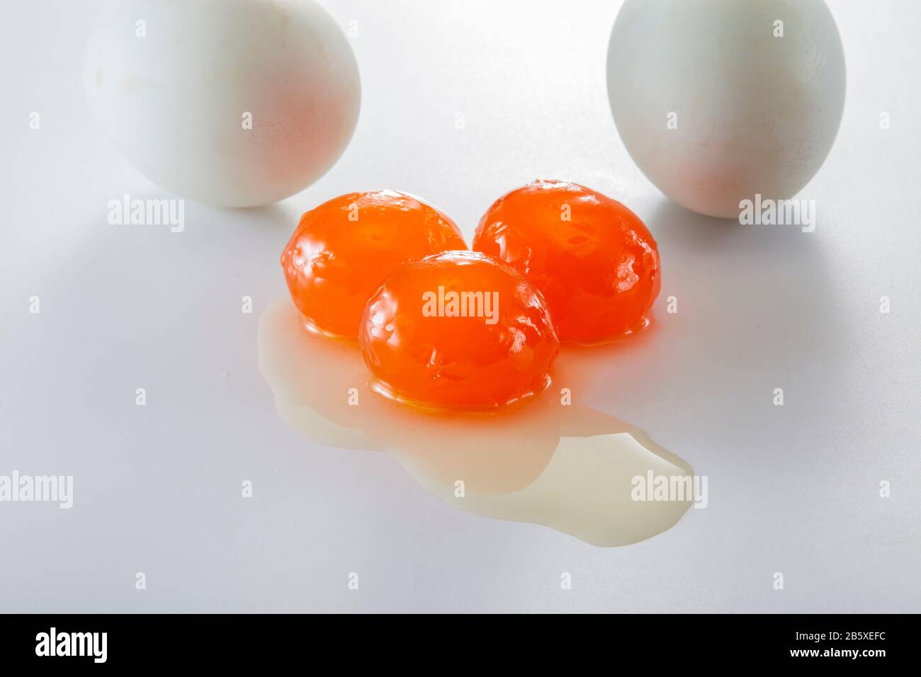 Three salted duck yolks and a pile of salted duck eggs Stock Photo - Alamy