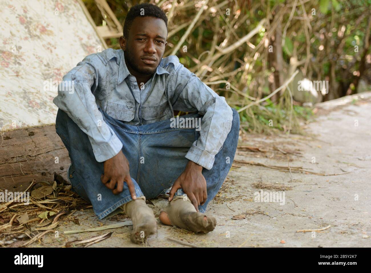 Sad young homeless African man in the streets Stock Photo - Alamy