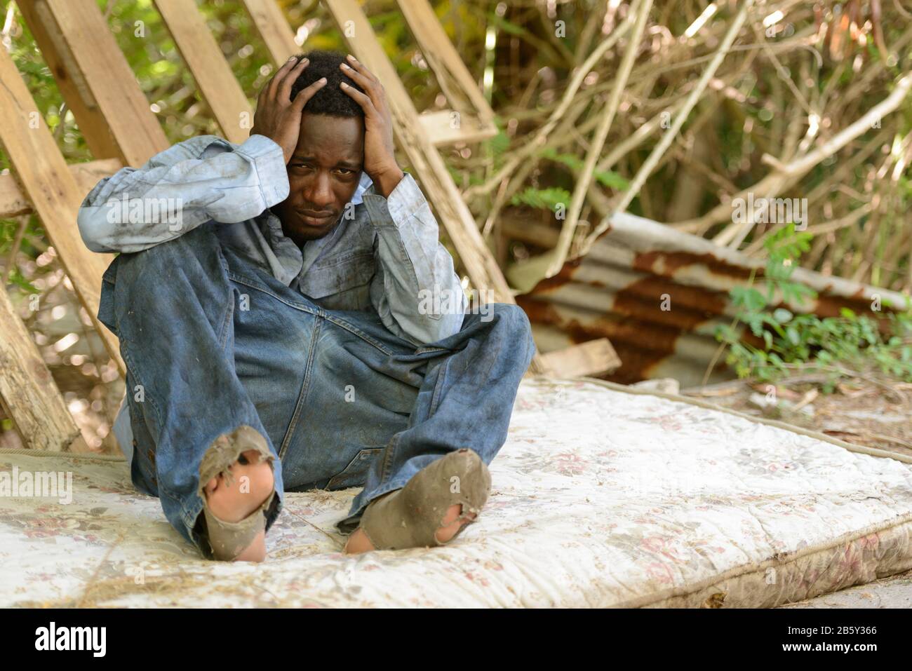 Young homeless African man looking depressed in the streets Stock Photo ...