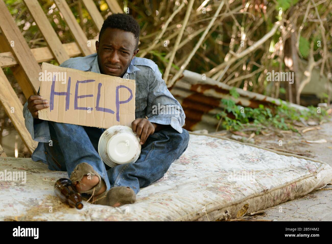 Young homeless African man with cardboard sign asking for help Stock ...