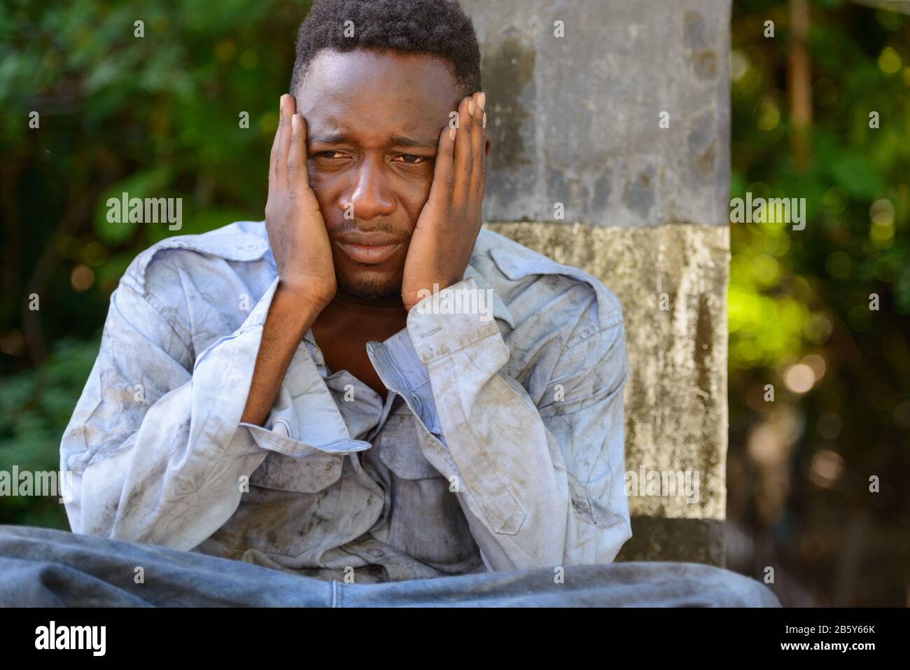 Young homeless African man looking depressed on the bridge Stock Photo ...