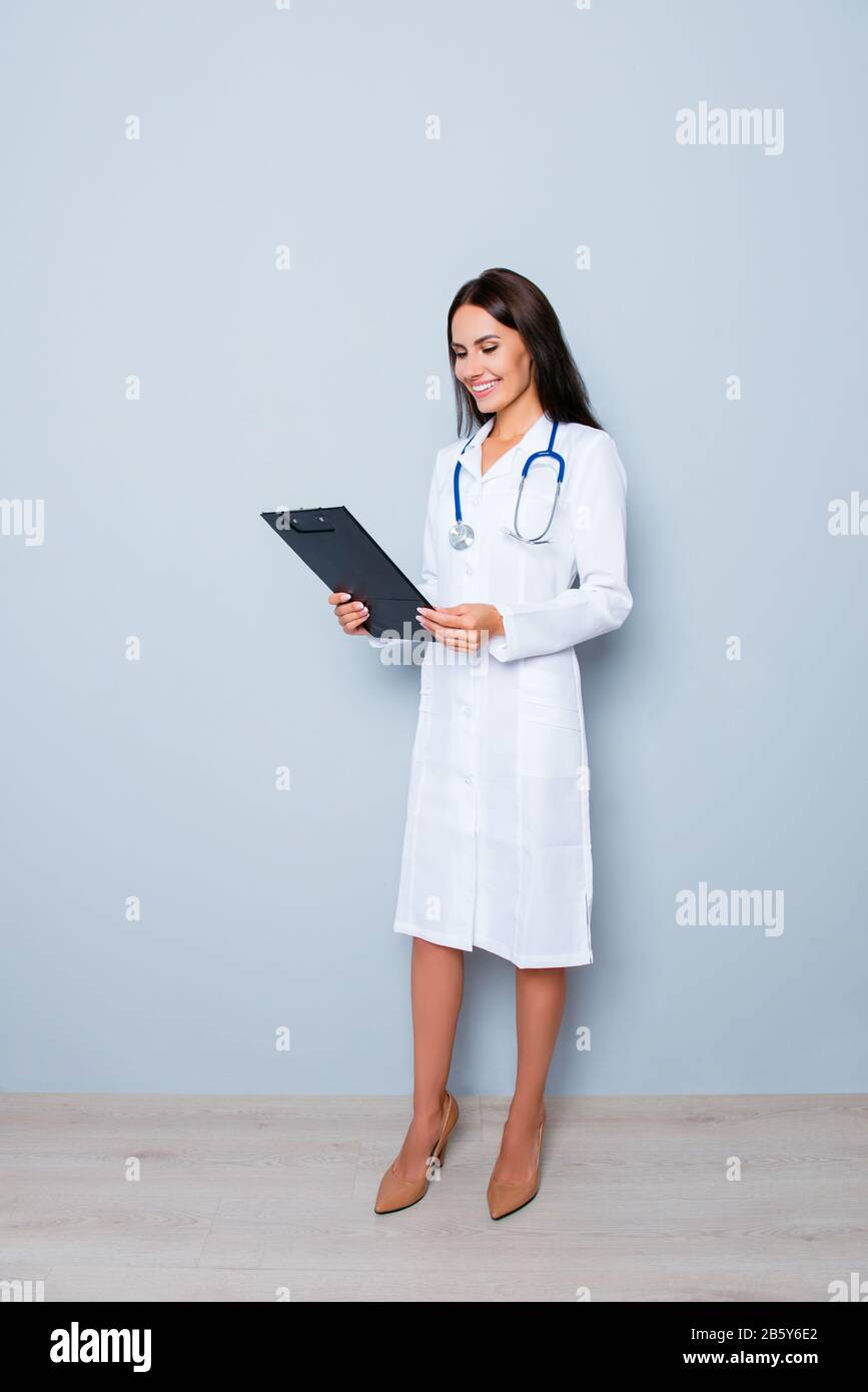 Full photo of young happy doc holding folder and reading diagnosis ...
