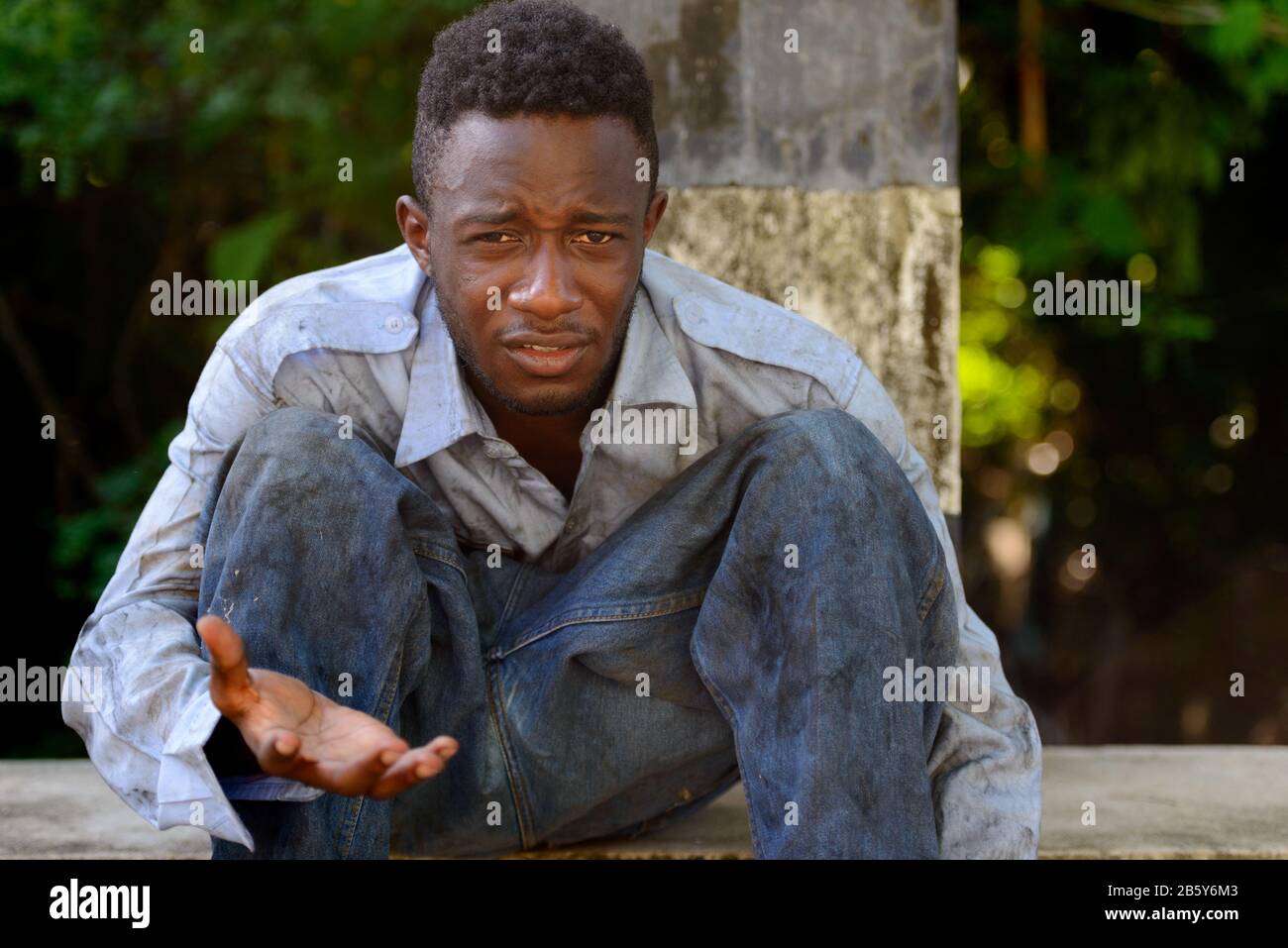 Young homeless African man begging on the bridge Stock Photo - Alamy