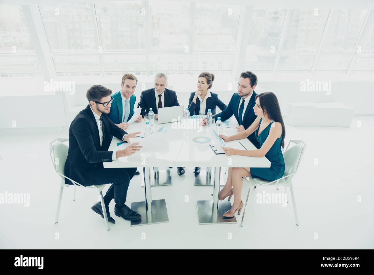 Group of successful businesspeople talking together while working ...