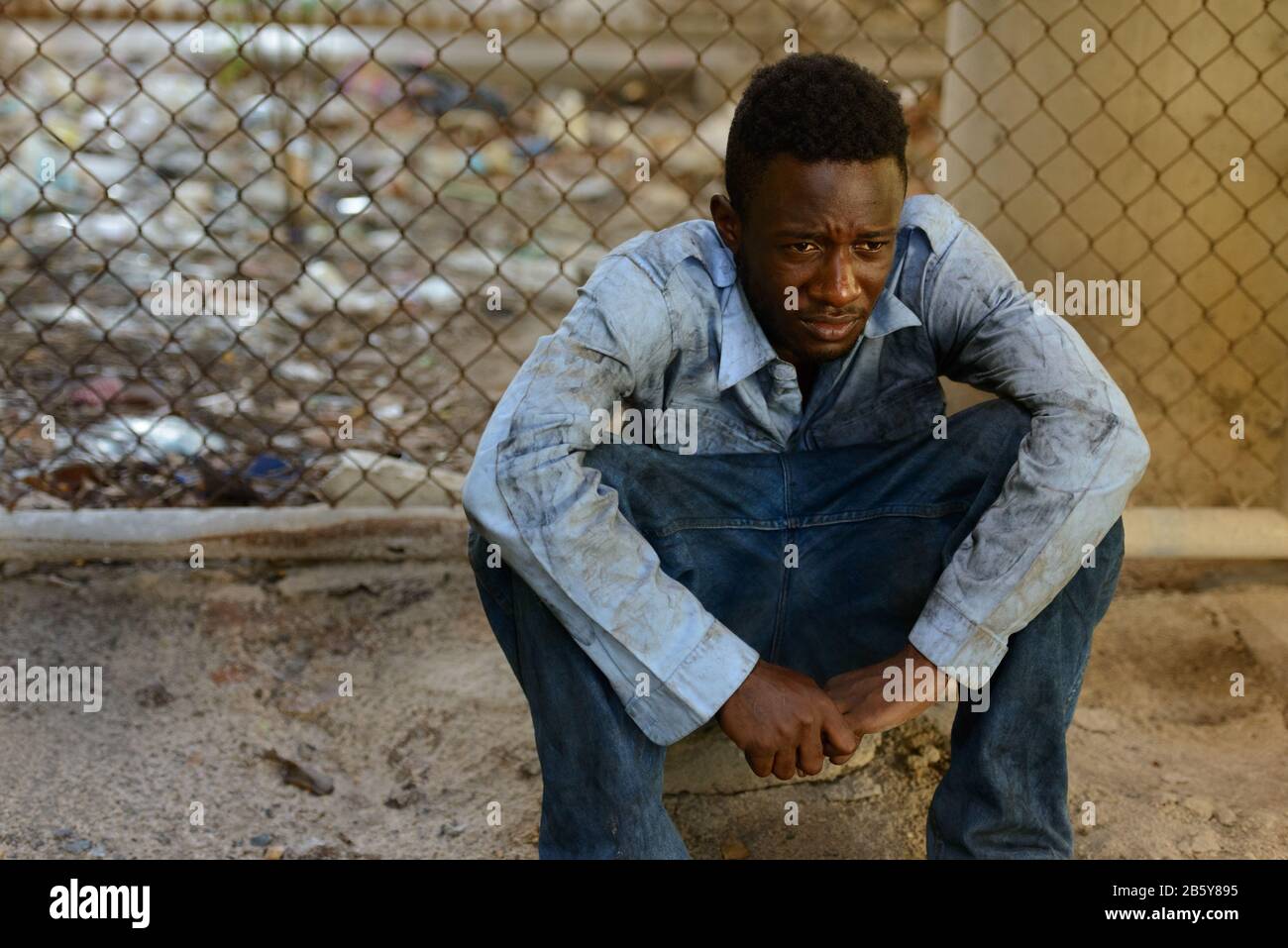 Young homeless African man sitting in the streets Stock Photo - Alamy
