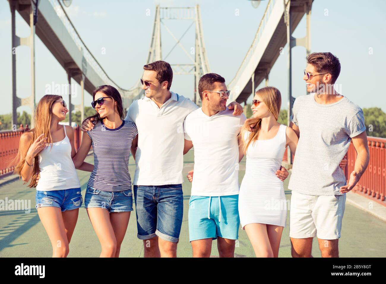 Portrait of six cheerful best friends walking on the bridge Stock Photo ...