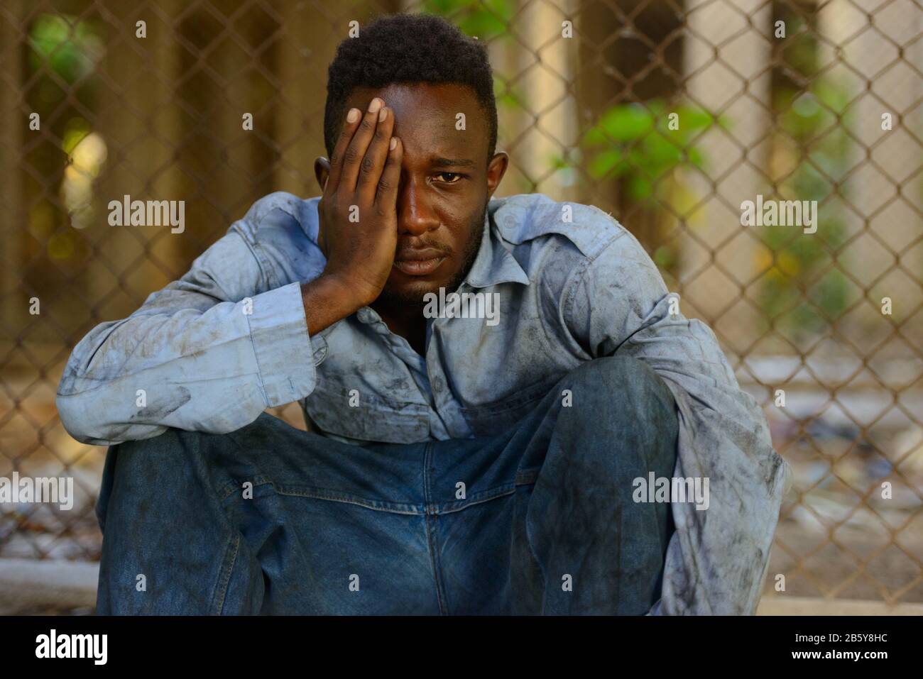 Young homeless African man looking depressed in the streets Stock Photo ...