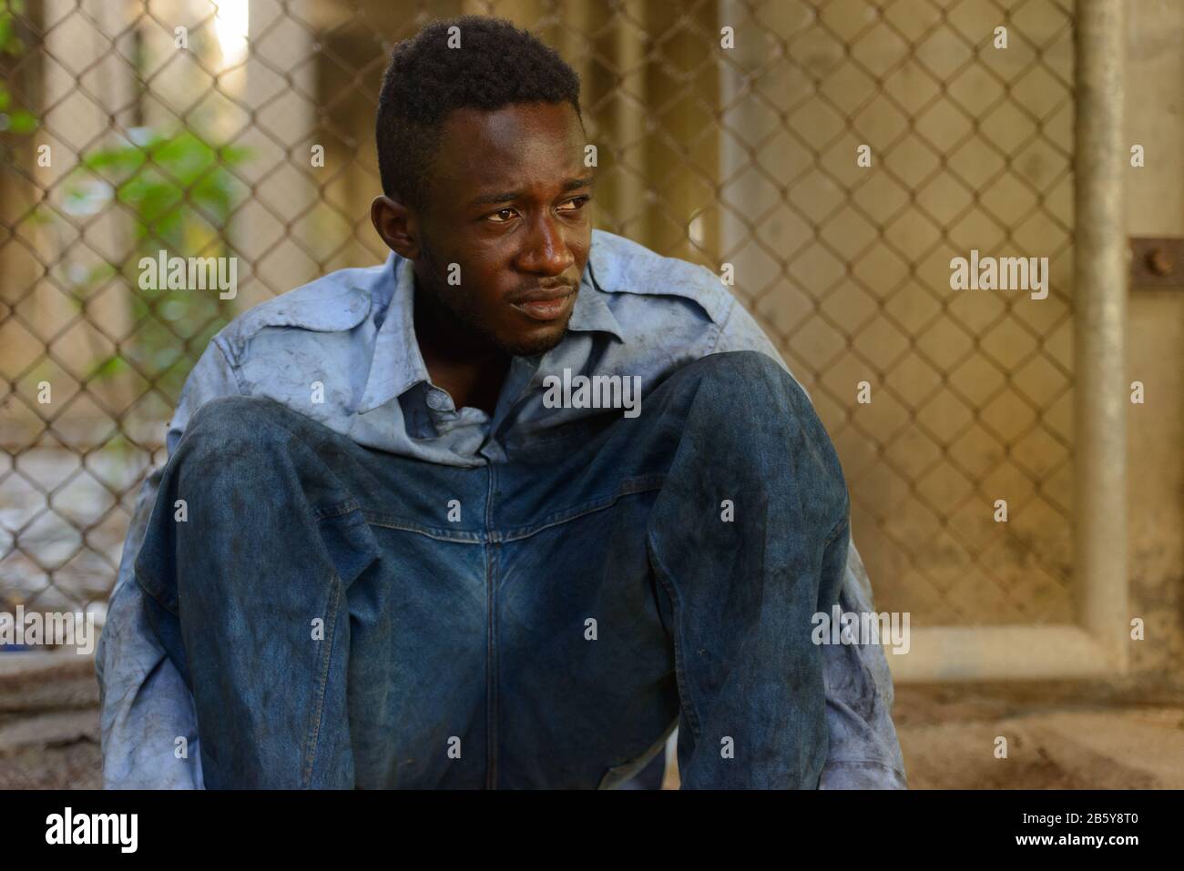 Young homeless African man sitting in the streets Stock Photo - Alamy
