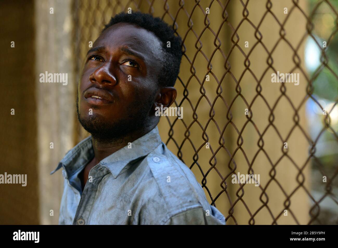 Face of young homeless African man looking up in the streets Stock ...
