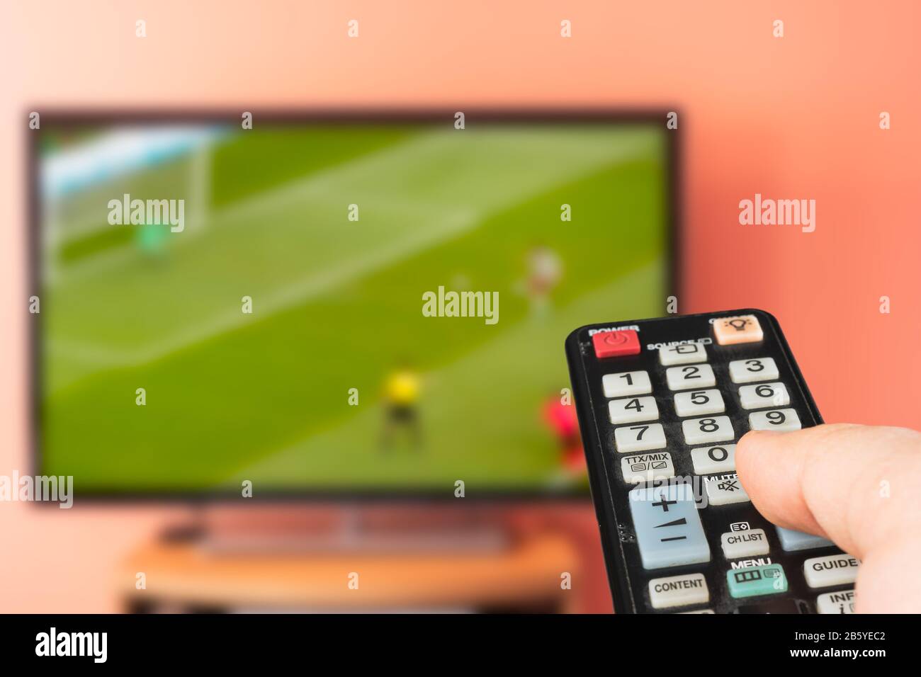 Caucasian man watching soccer or football on TV at home. Changing ...