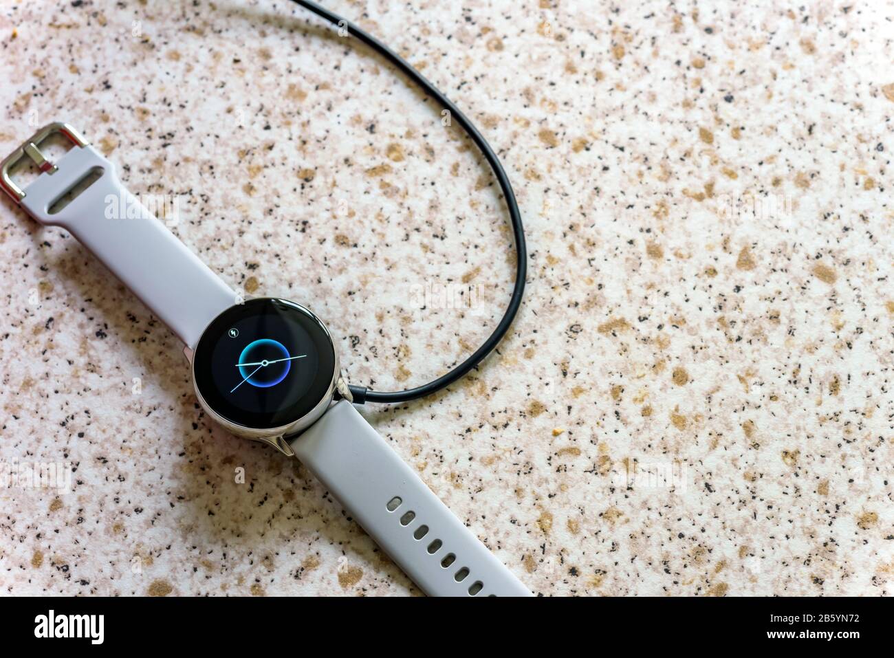 smart watch wireless charging on charging pad on kitchen worktop table ...