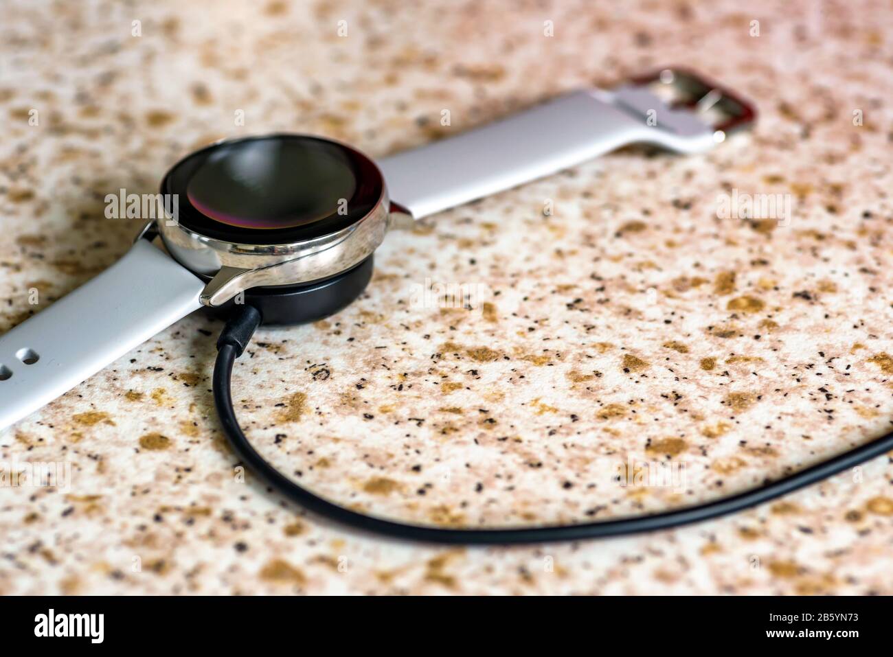 smart watch wireless charging on charging pad on kitchen worktop table ...