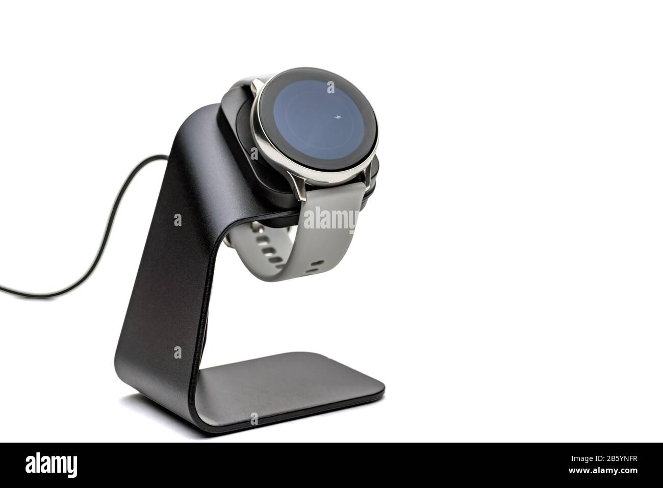 smart watch charging on wireless charging stand pad on white background ...